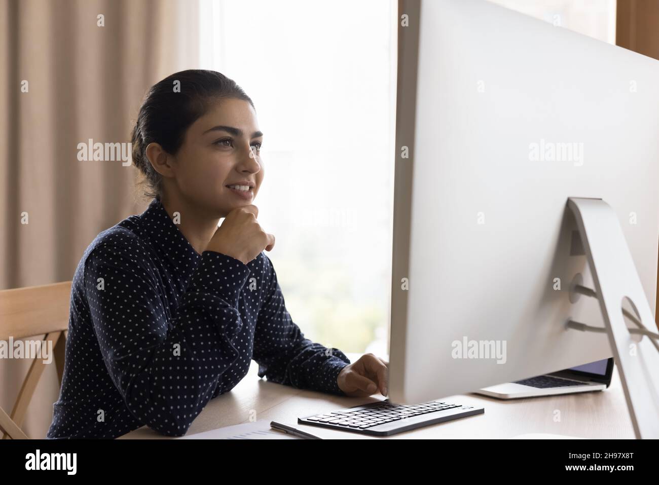 Happy successful Indian female business leader working at desktop ...