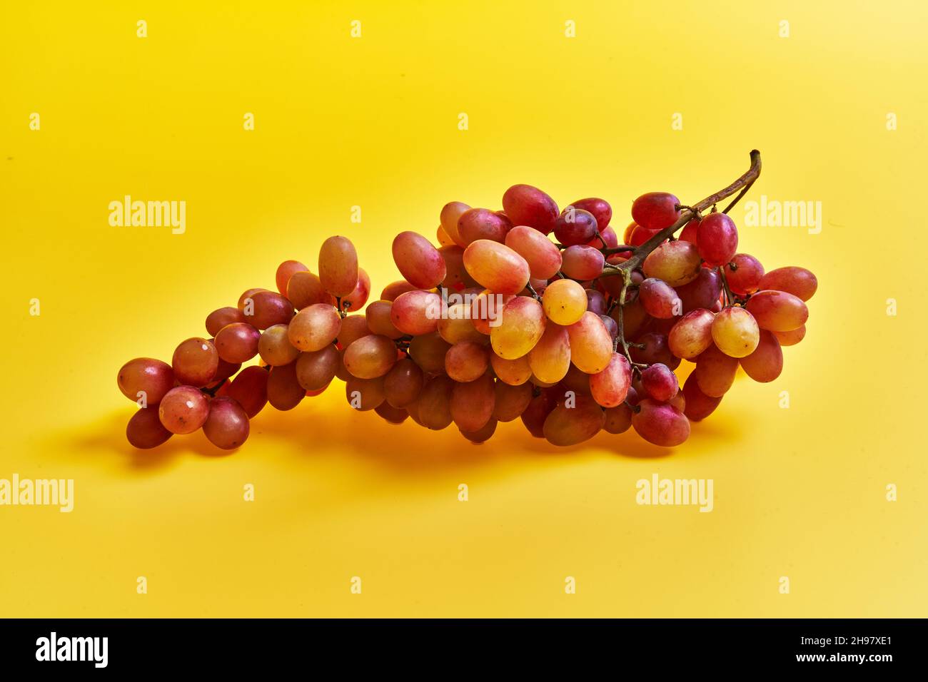 Bunch of grapes over yellow background Stock Photo - Alamy