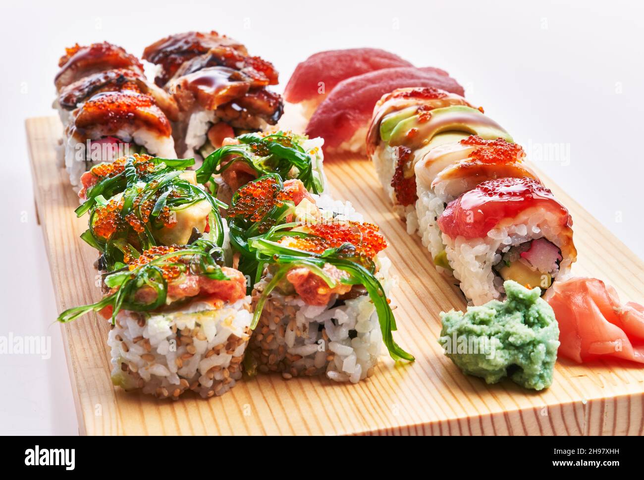 Wooden board of sushi isolated over white background Stock Photo - Alamy