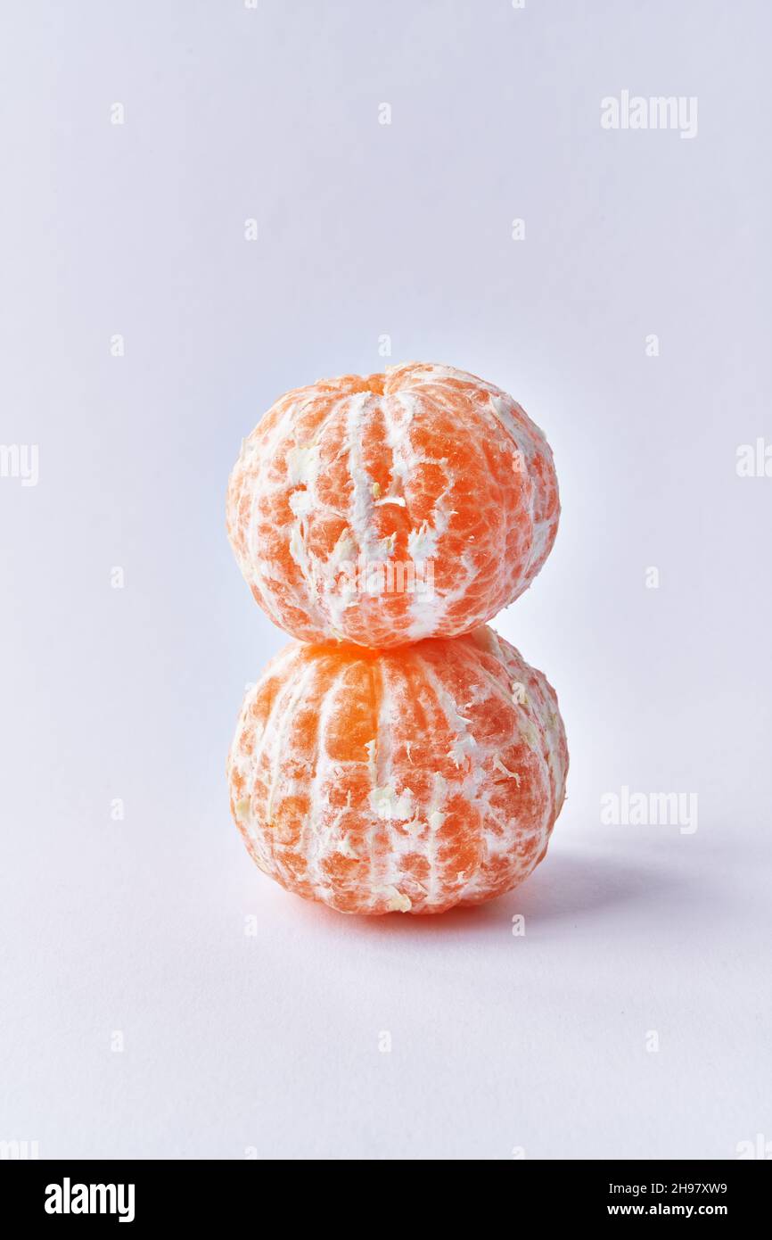 Two peeled tangerines isolated over white background Stock Photo - Alamy