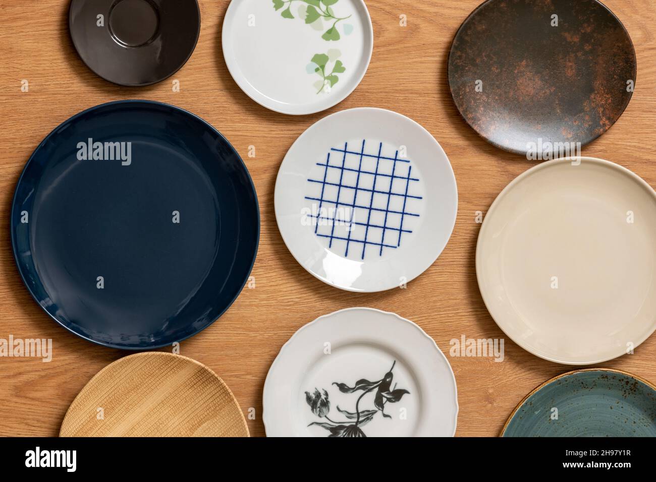 set of empty assorted plates on wooden table Stock Photo - Alamy