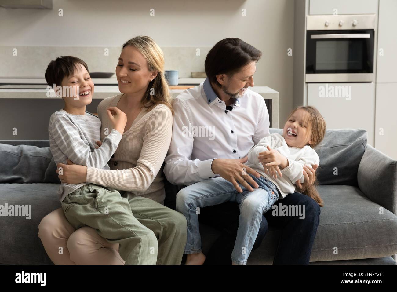 Happy loving young parents having fun with kids Stock Photo - Alamy