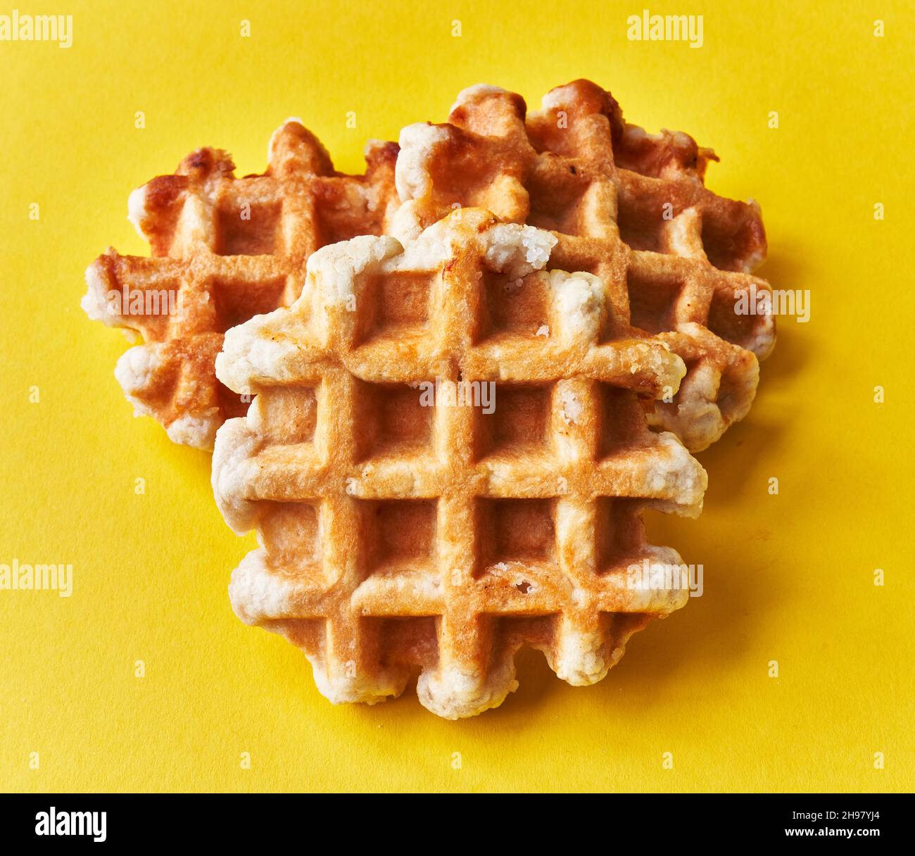 Bunch of delicious waffles over yellow background Stock Photo - Alamy
