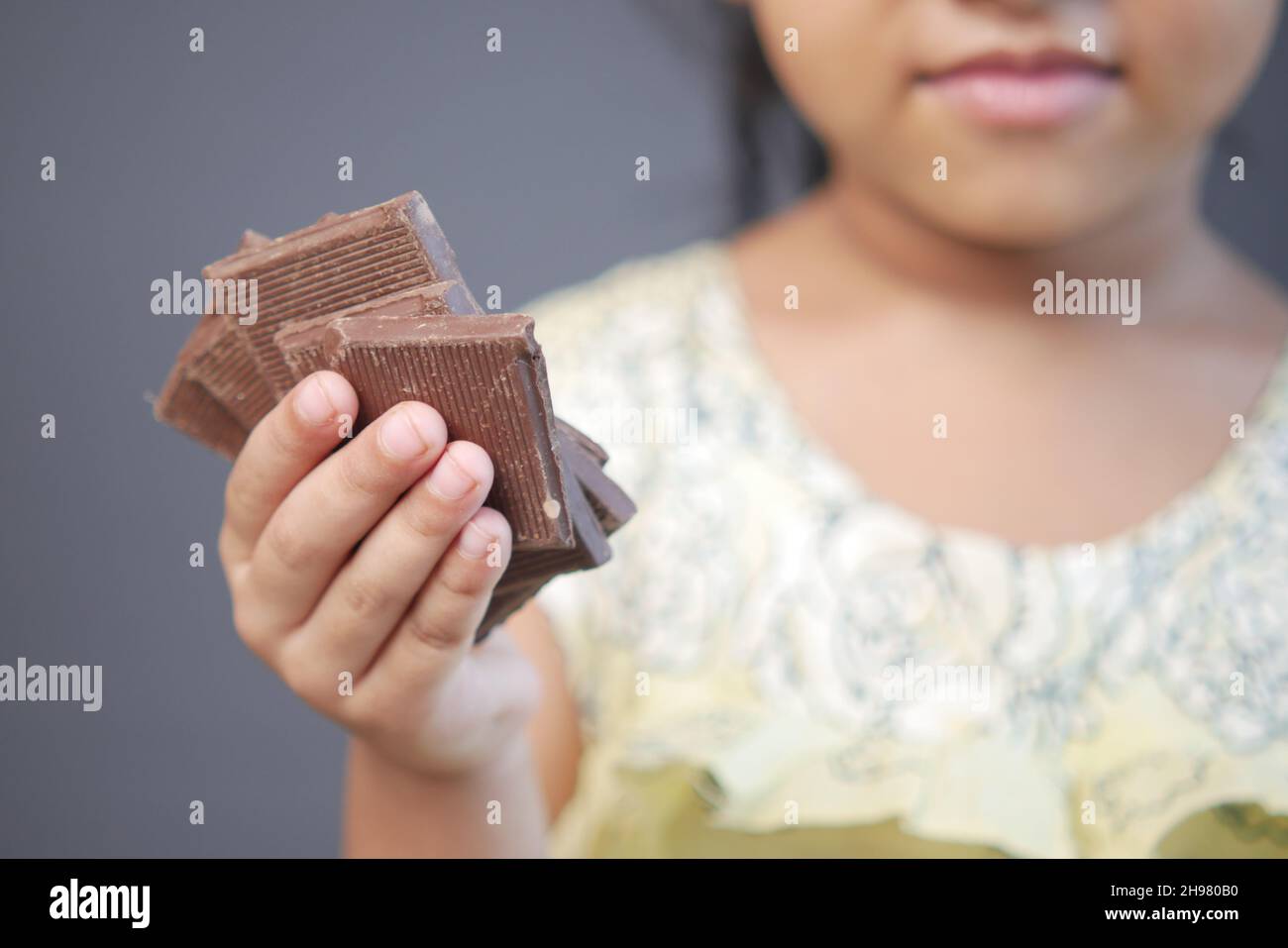 child girl hand pick dark chocolate against gray background Stock Photo ...