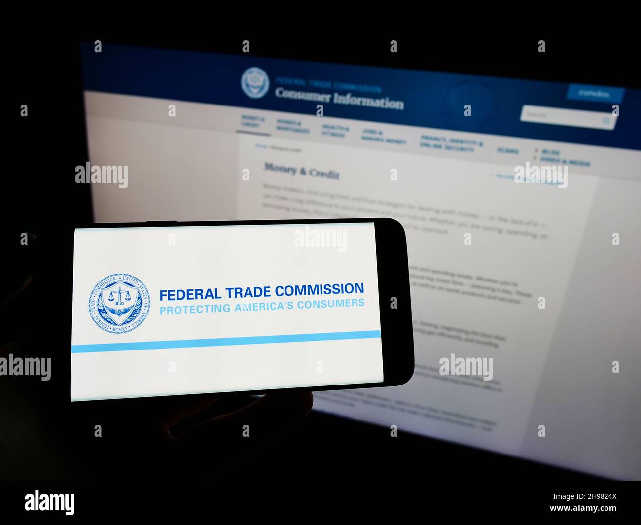 Person holding cellphone with logo of US government agency Federal ...