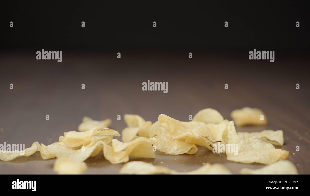 potato chips falling on wood backgorund, wide photo Stock Photo - Alamy