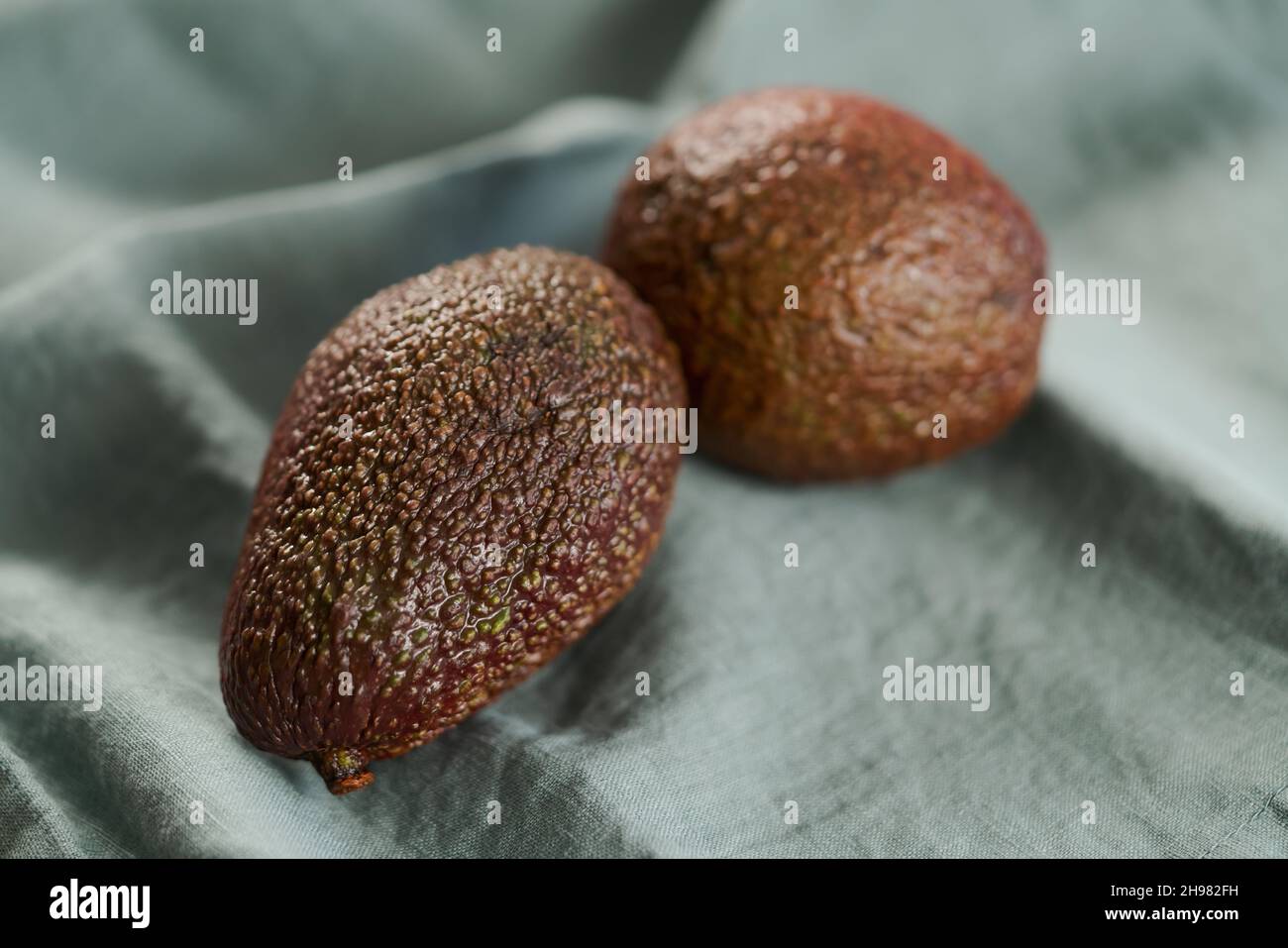 Two avocados on linen cloth, shallow focus Stock Photo - Alamy