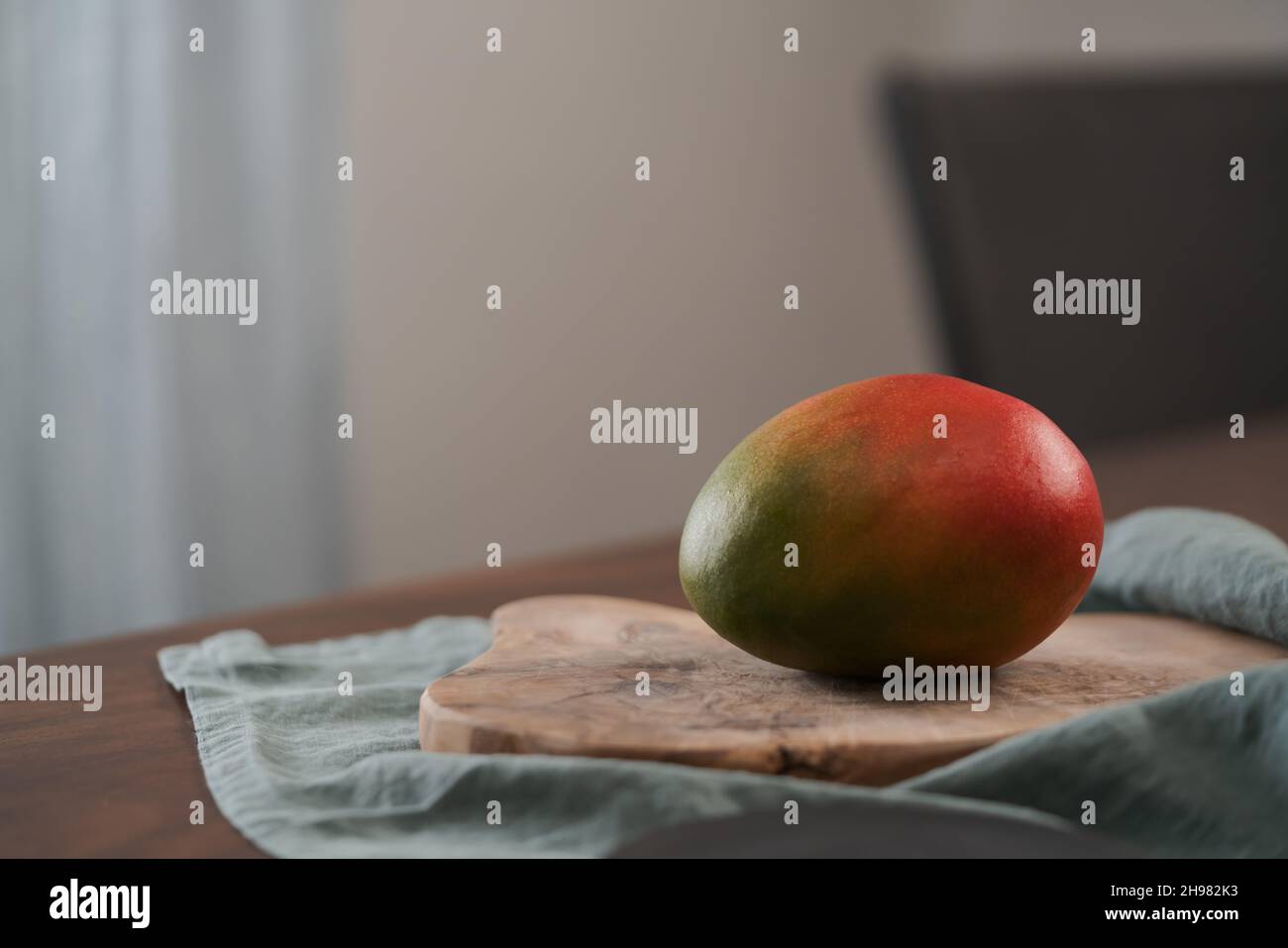 Whole ripe red mango on olive wood board, shallow focus Stock Photo - Alamy