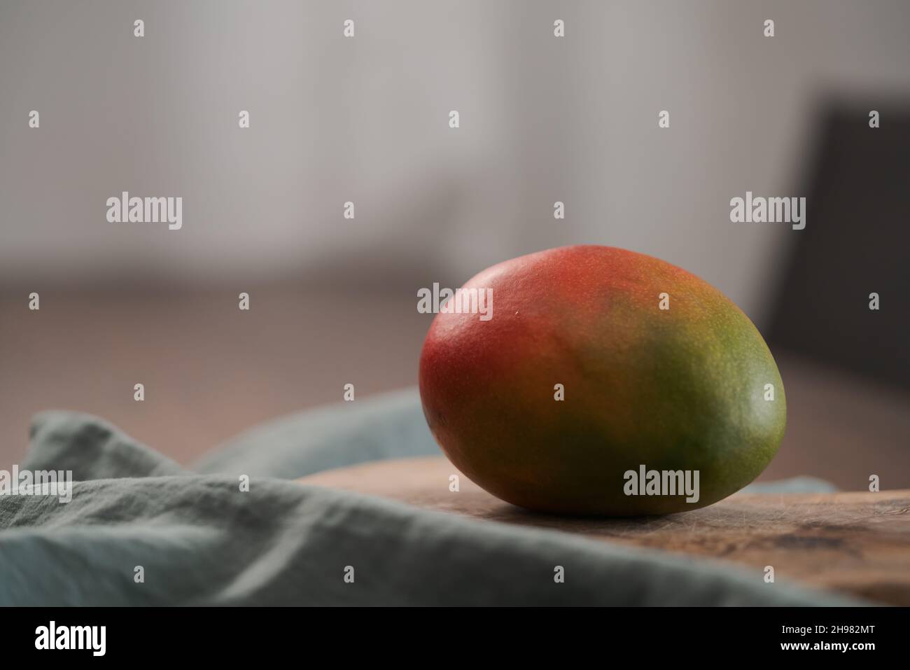 Whole ripe red mango on olive wood board, shallow focus Stock Photo - Alamy