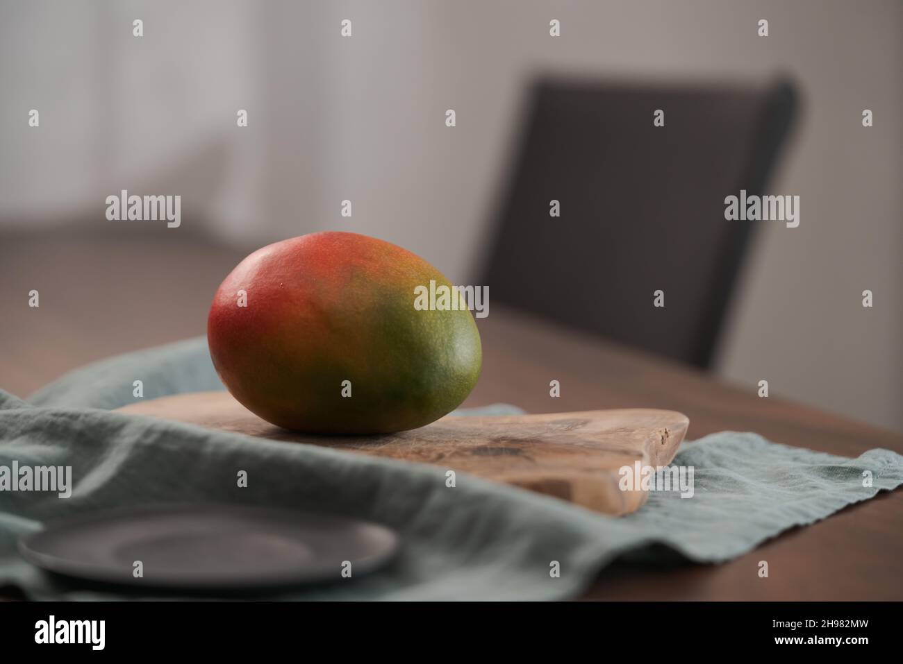 Whole ripe red mango on olive wood board, shallow focus Stock Photo - Alamy