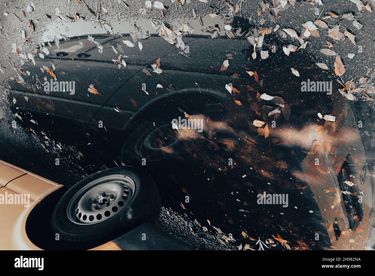A car and its reflection on the wet ground Stock Photo - Alamy