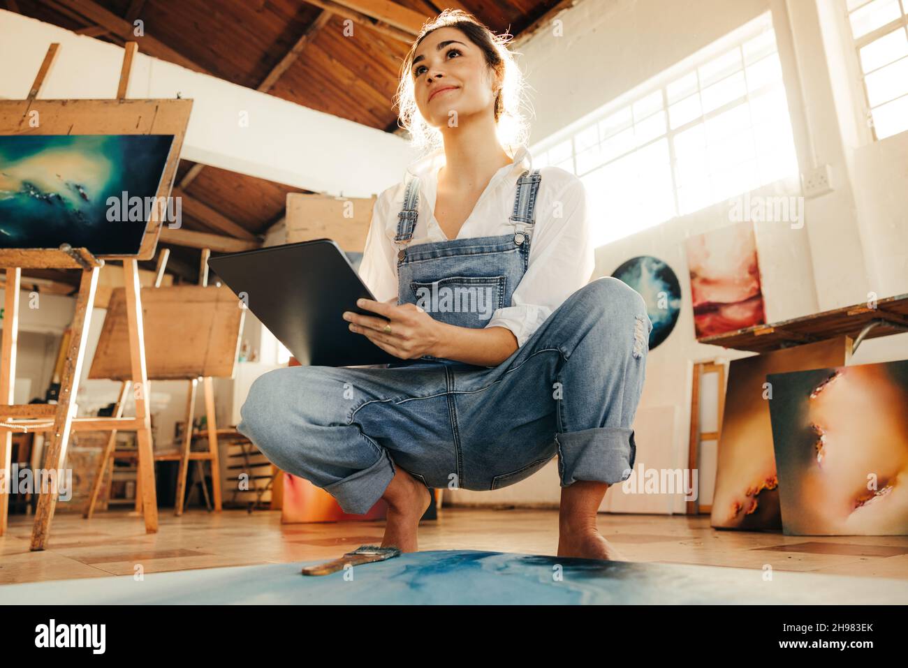 Self-employed painter looking thoughtful in her art studio. Creative ...