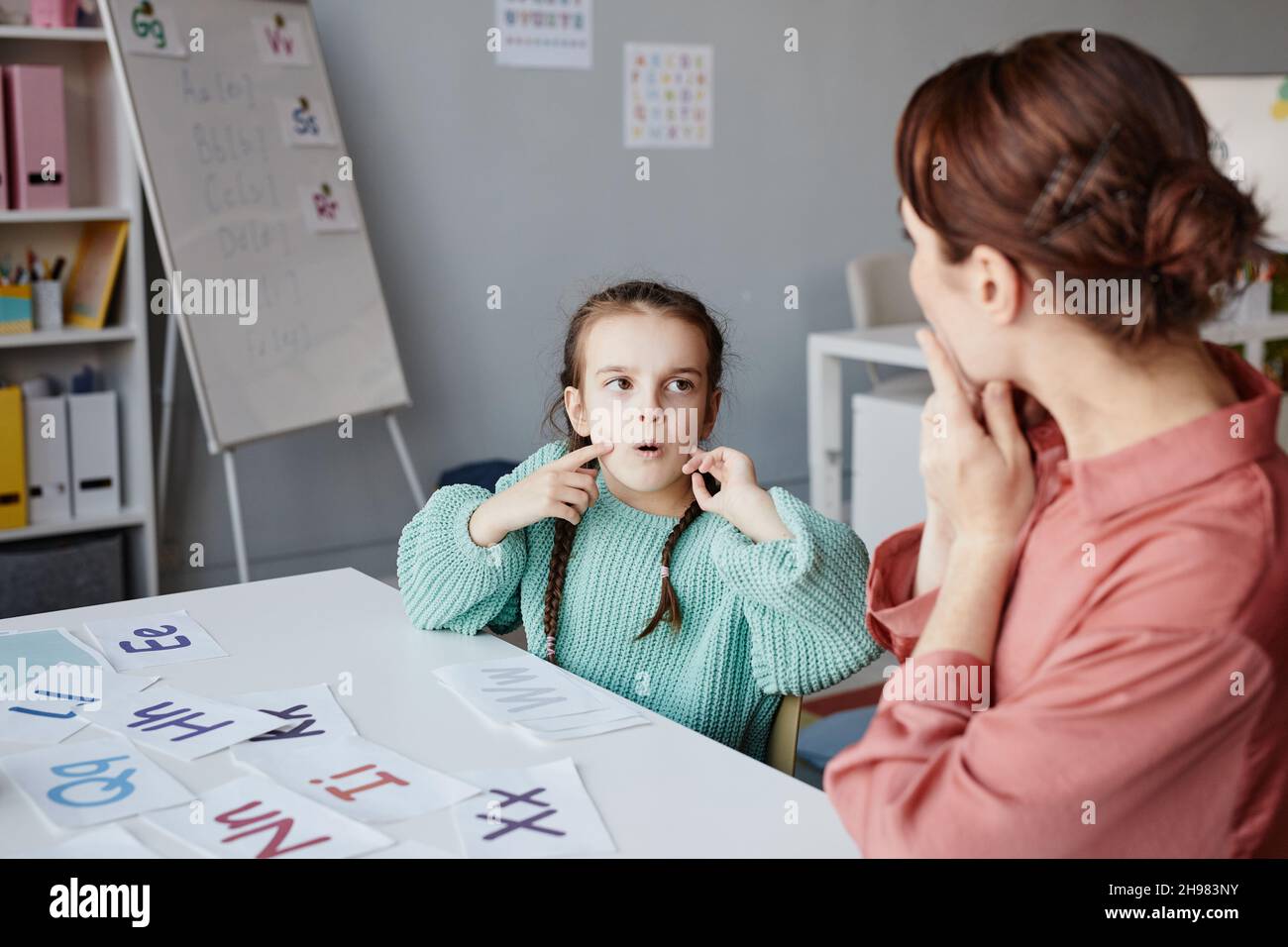Little Schoolgirl Learning To Read English Words Together With The 