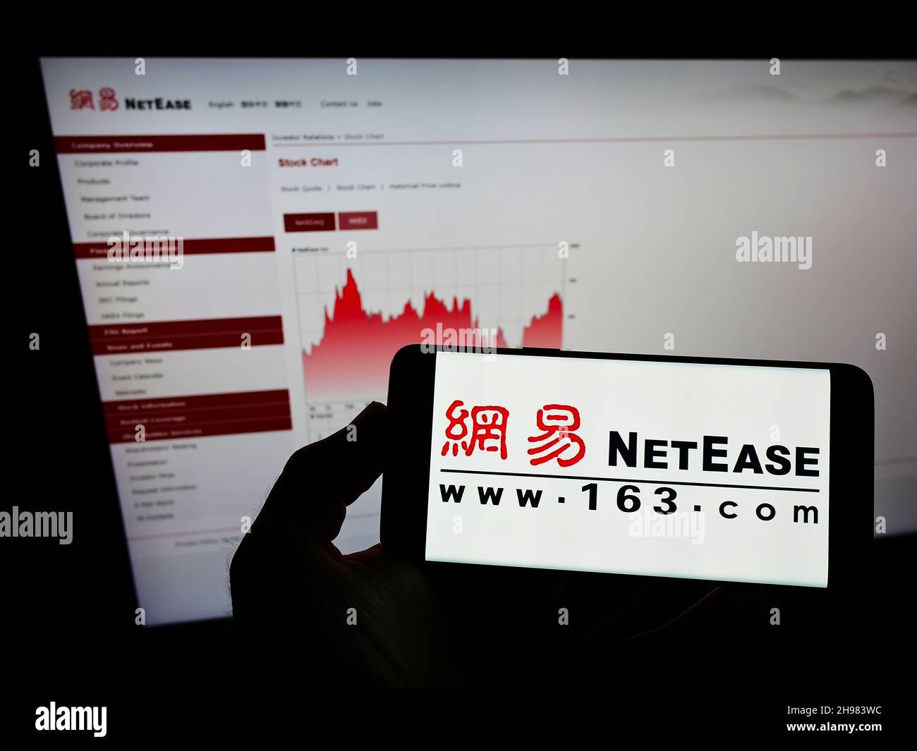 Person holding mobile phone with logo of Chinese technology company ...