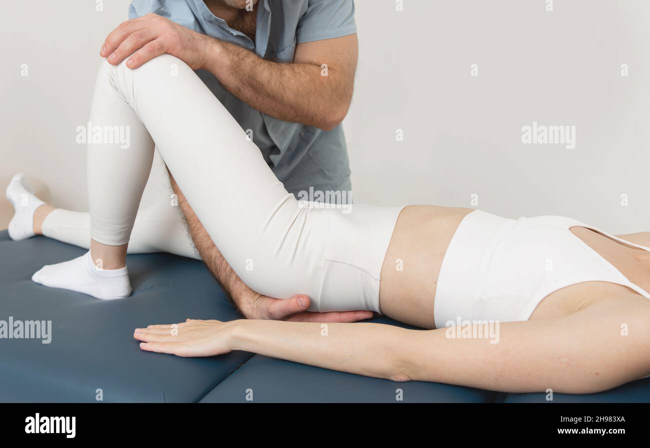 Knee pain relief in clinic. Doctor physiotherapist doing healing ...