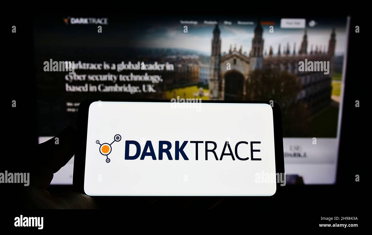 Person holding mobile phone with logo of cyber defence company ...