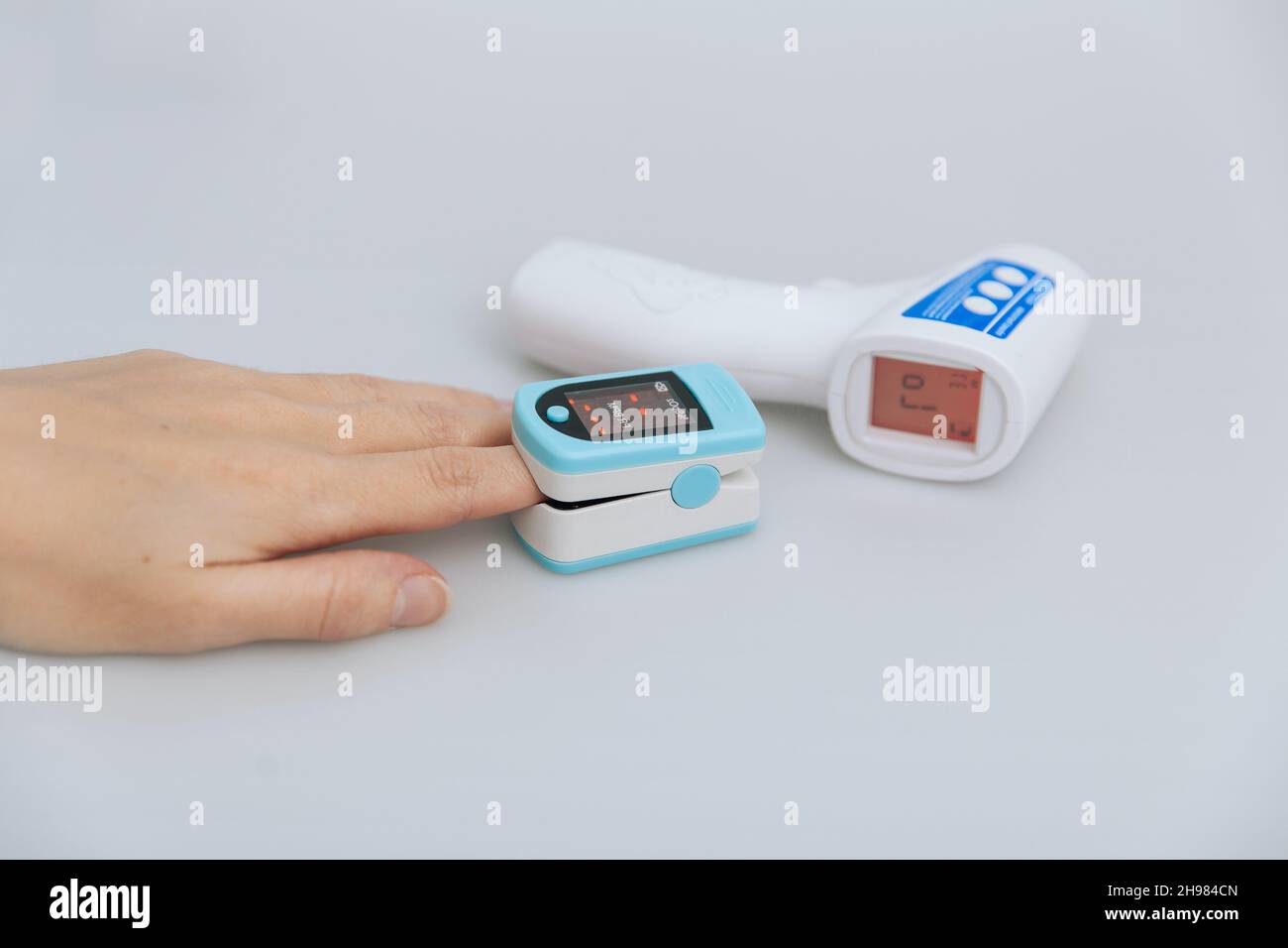 Pulse oximeter and thermometer gun on white background. Infrared ...