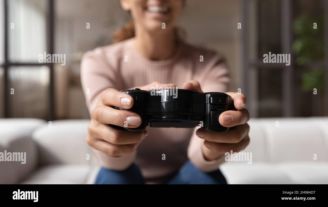 Close up cropped excited woman using remote controller, playing game ...