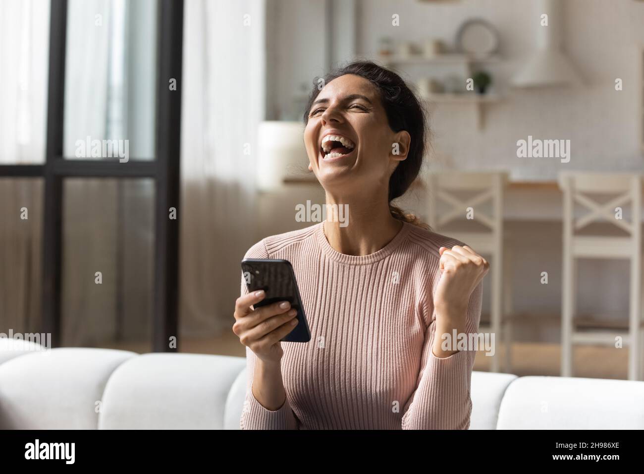 Close up overjoyed woman screaming with joy, holding smartphone Stock ...