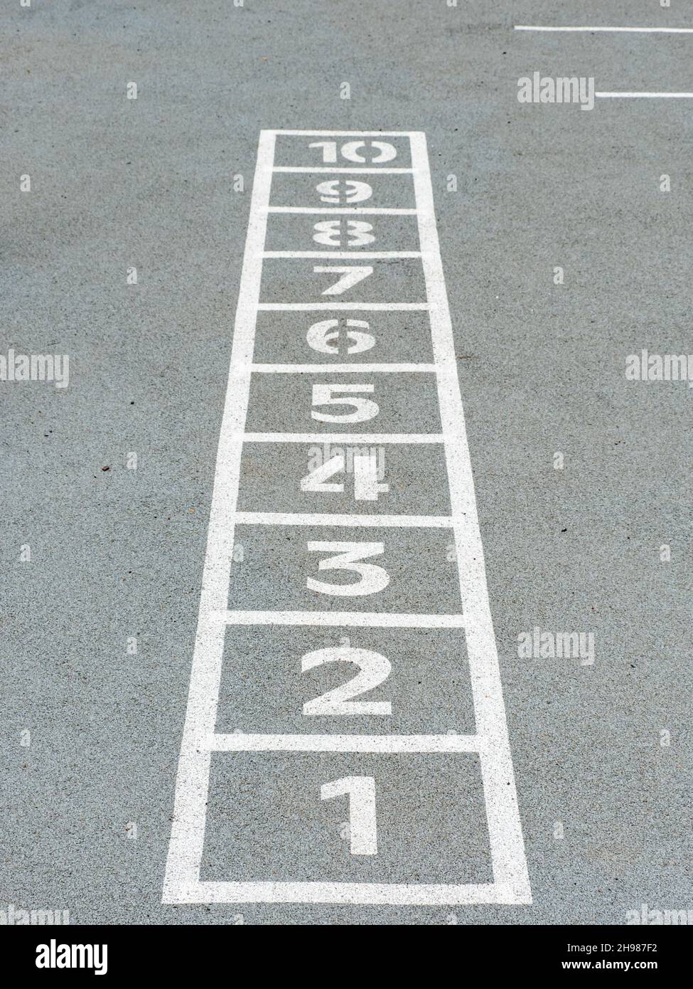 Classic Hopscotch game being drawn with a chalk on the gray ground as ...
