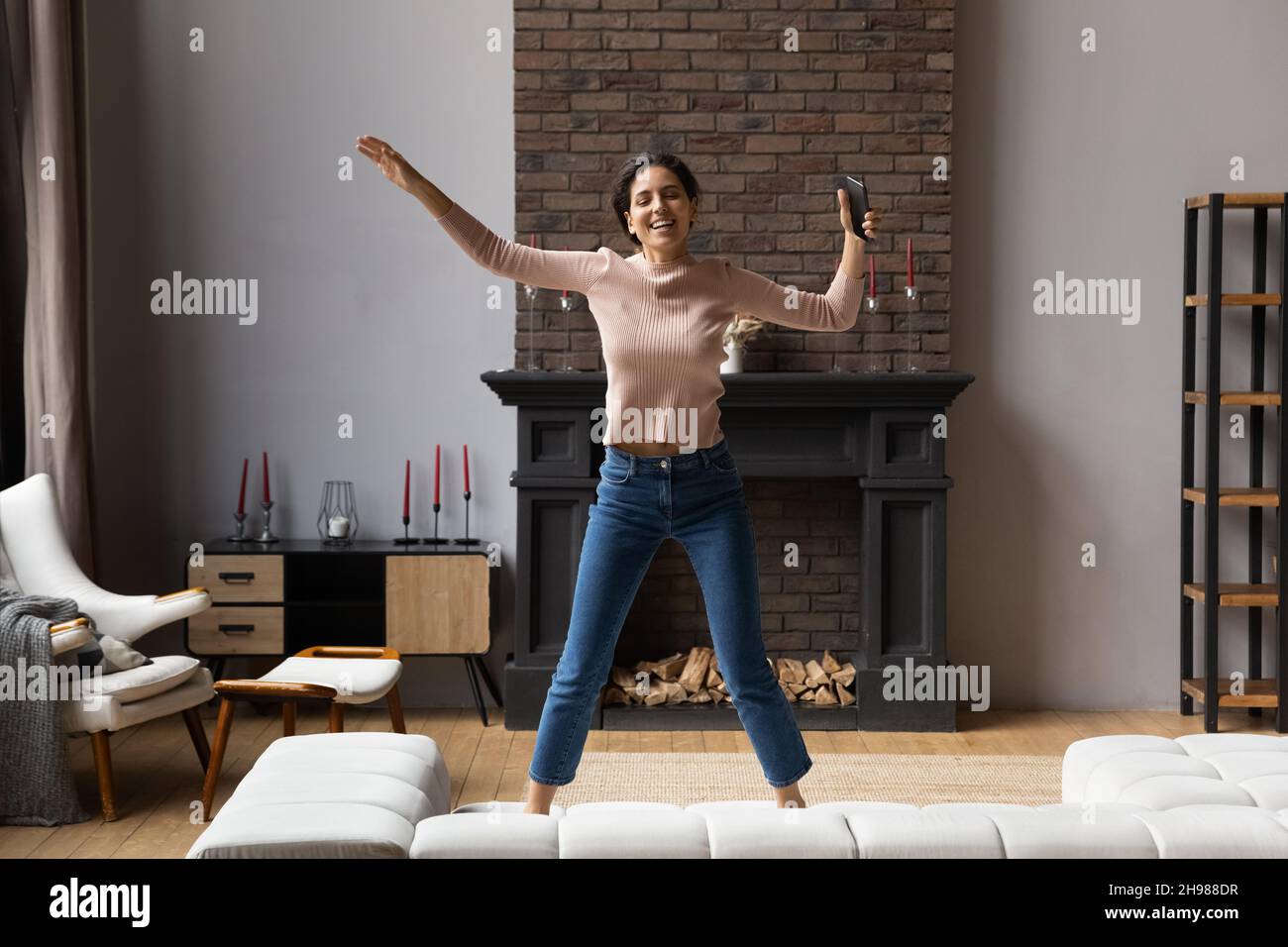 Girl jumping on couch hi-res stock photography and images - Alamy