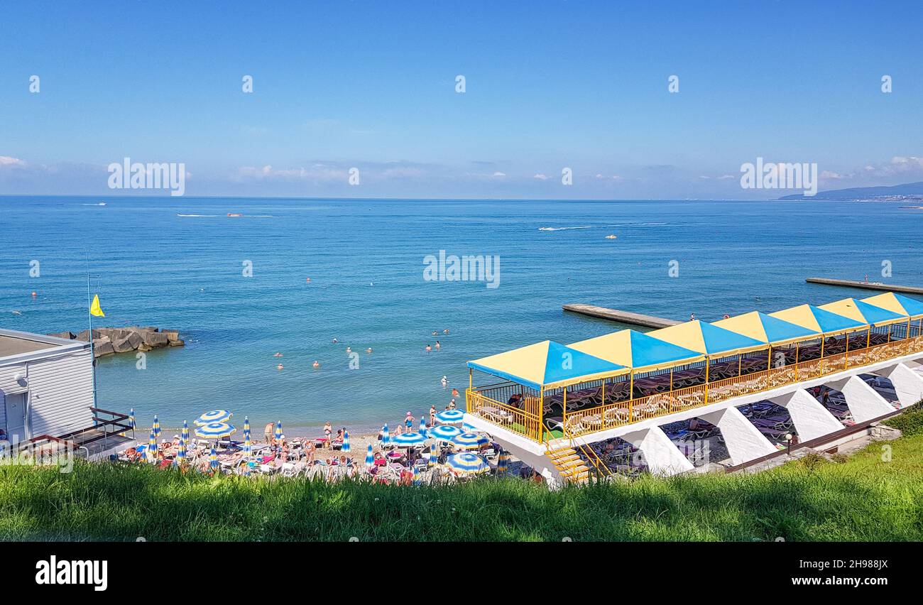 View of the beach with people, sun loungers, an air solarium with a ...