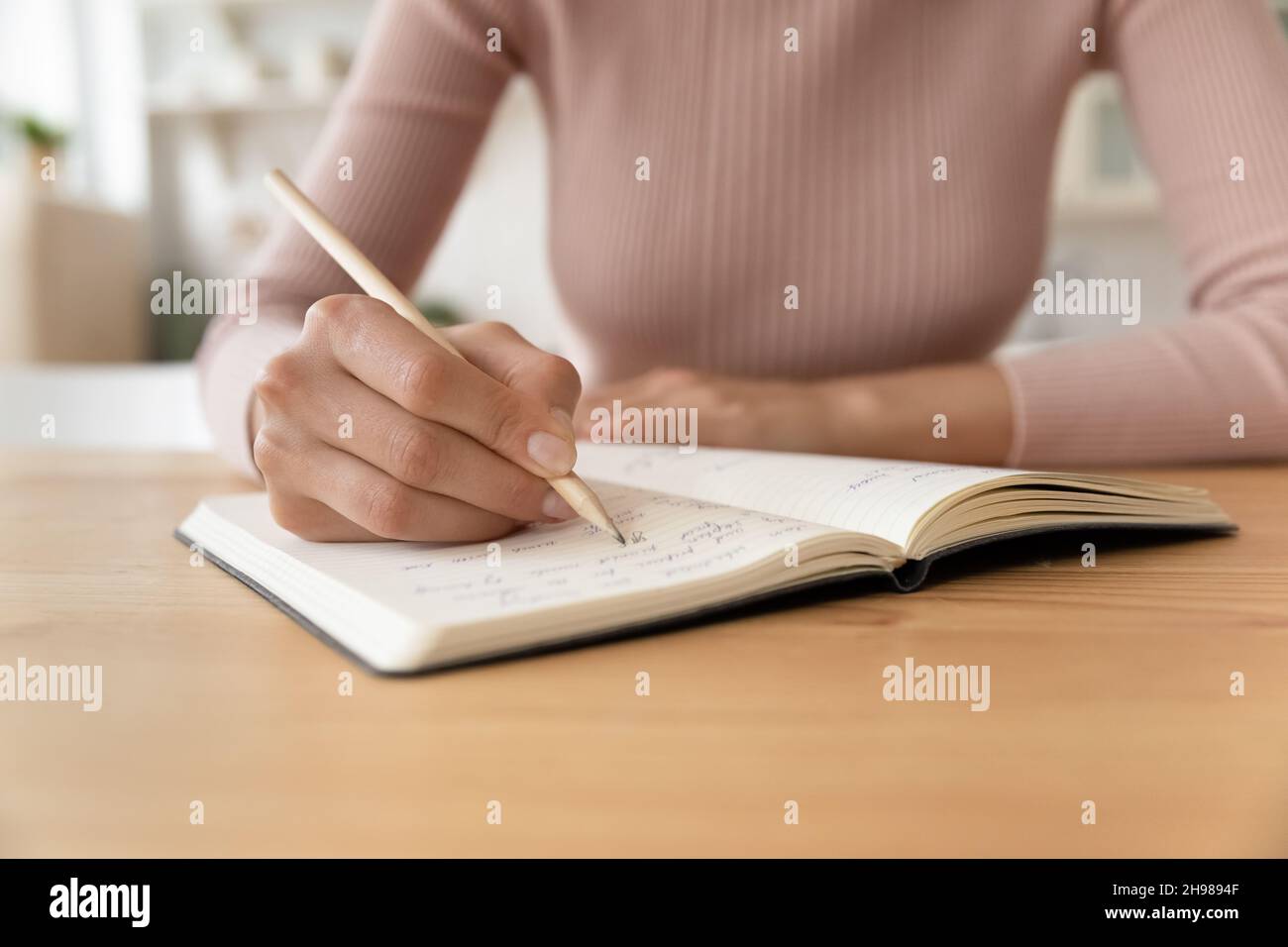 Close up cropped of woman taking notes in notebook Stock Photo - Alamy