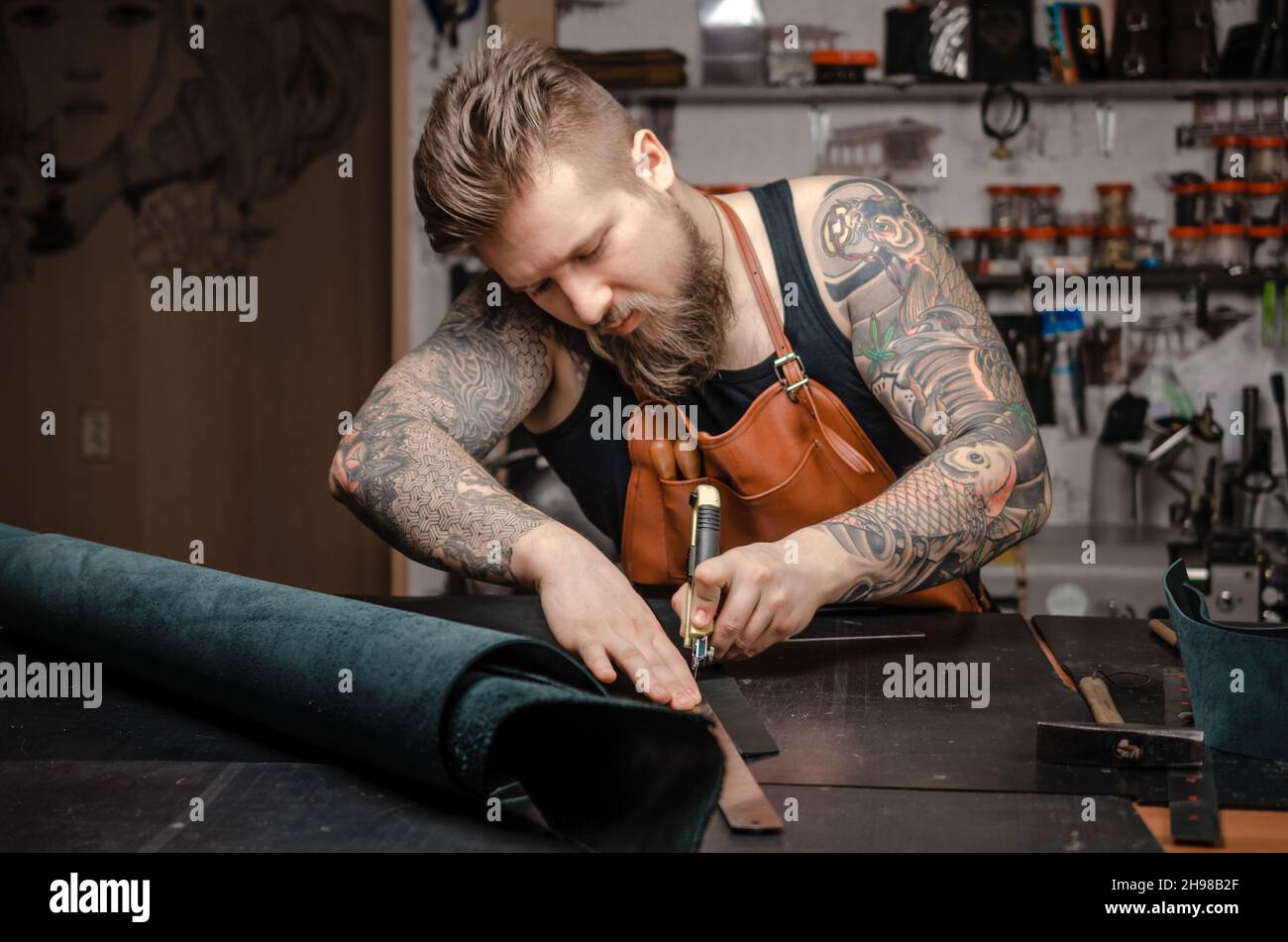 Leather Currier creating new leatherwork in his tanner shop Stock Photo ...
