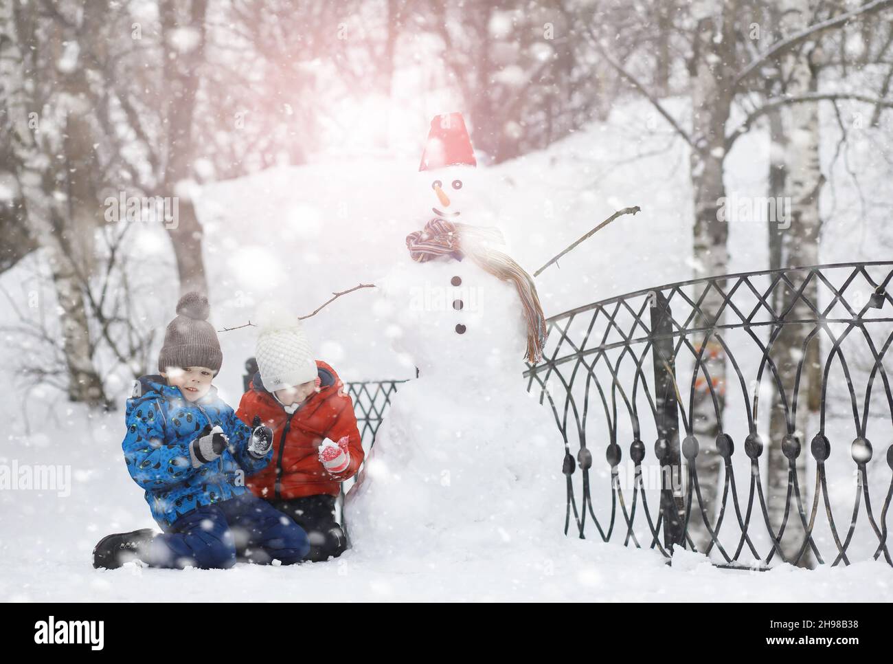 Children in the park in winter. Kids play with snow on the playground ...