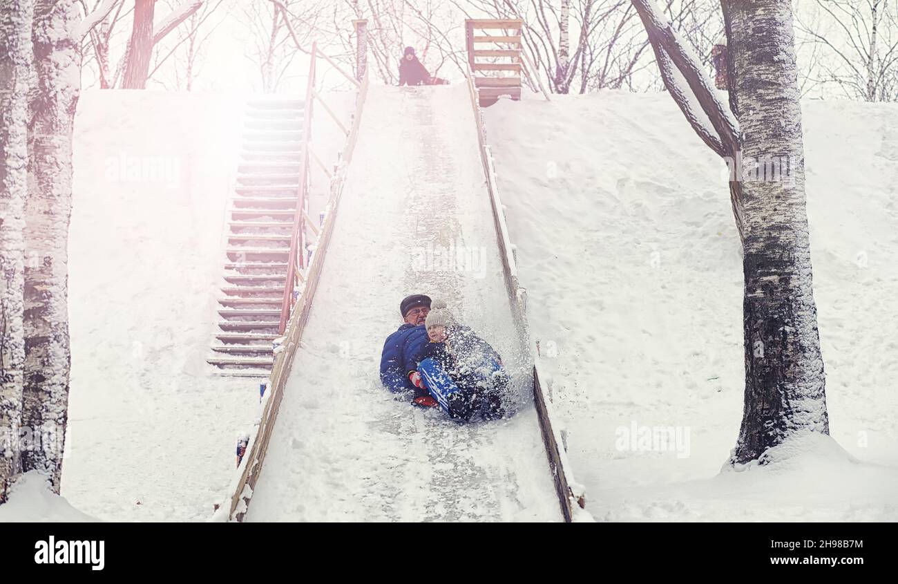 Children in the park in winter. Kids play with snow on playground. They ...
