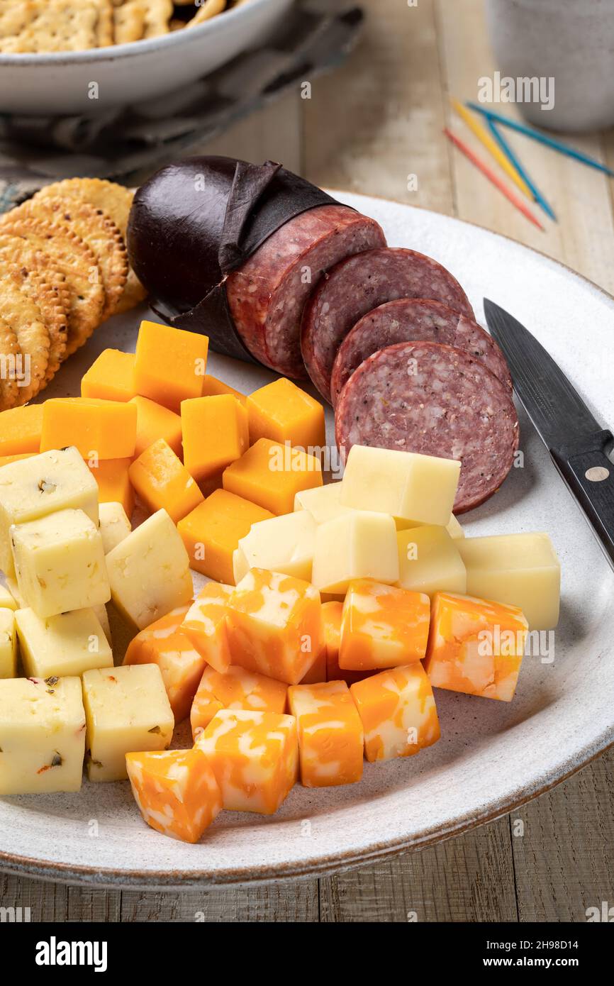 Assortment of cheese cubes on a platter wuth crackers and sausage on a ...