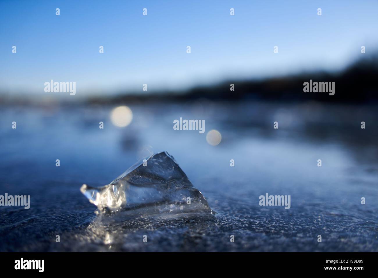 Ice splinters lies on a frozen lake. Depth of field, copy space. Dark ...