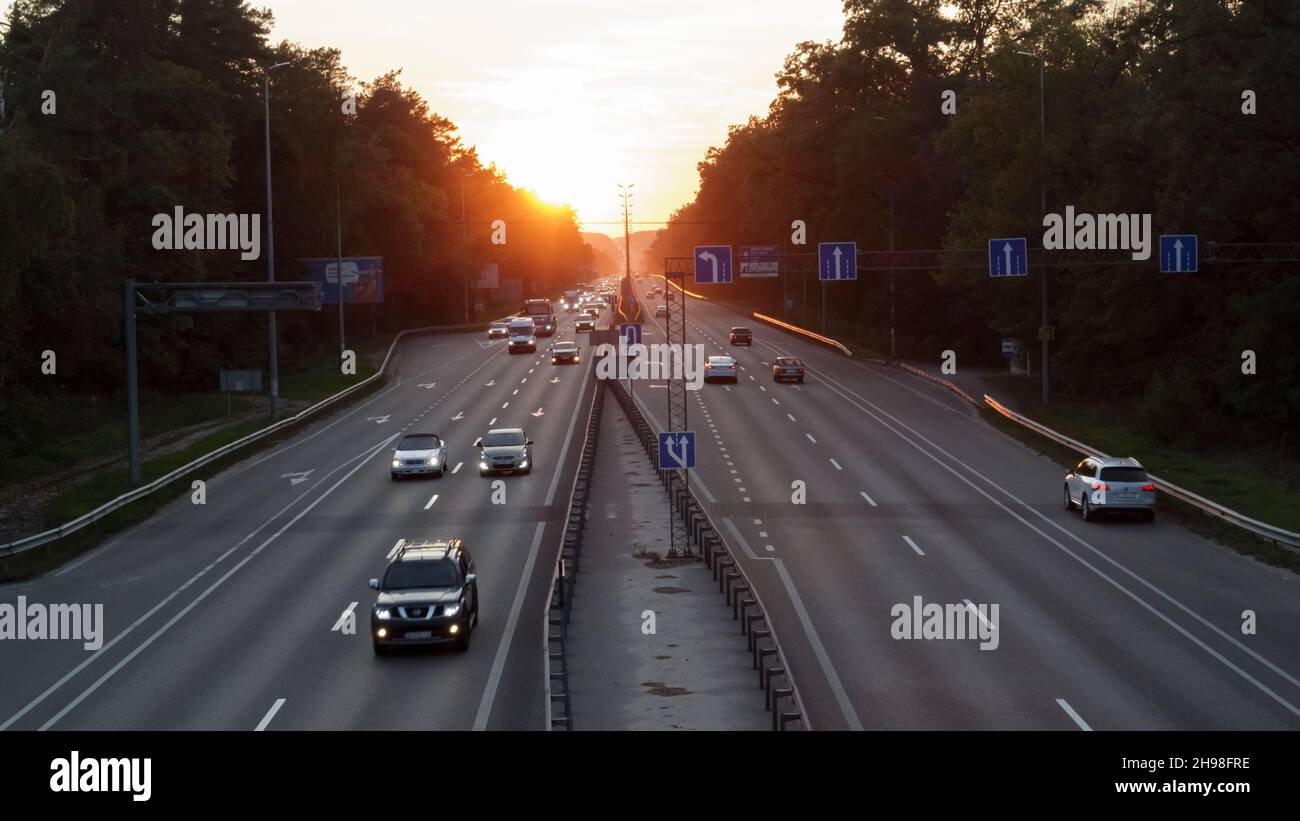 Moving cars on the motorway at sunset time. Highway traffic at sunset ...
