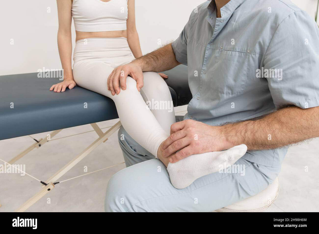 Knee pain relief in clinic. Doctor physiotherapist doing healing ...