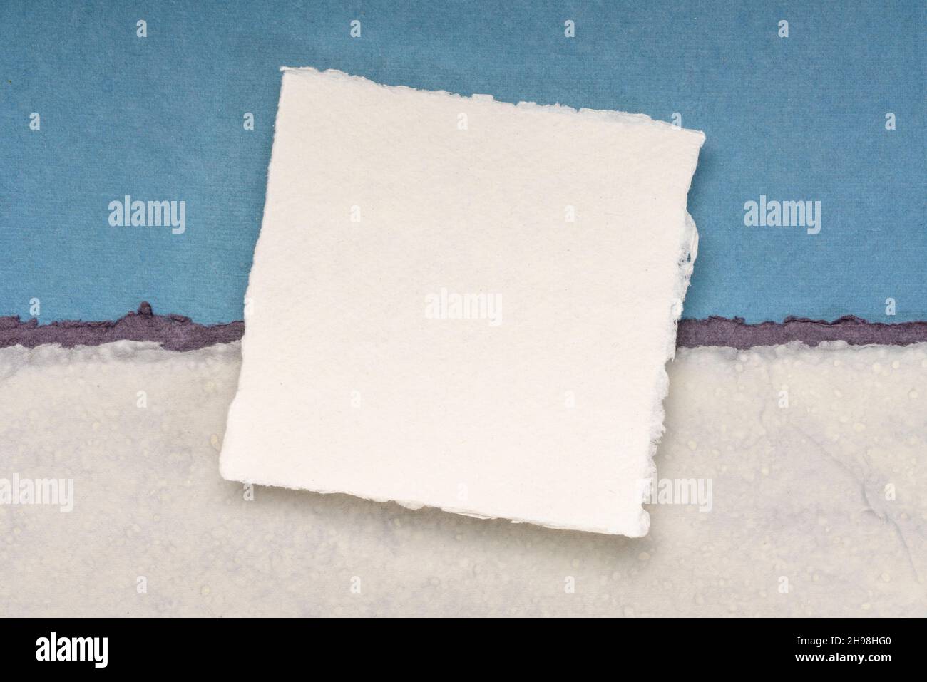 small square sheet of blank white Khadi paper against blue rag paper ...