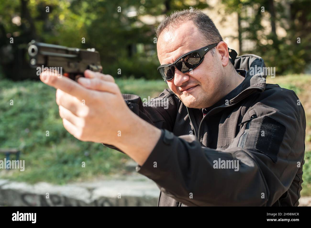 Police agent and bodyguard pointing pistol to protect from attacker ...