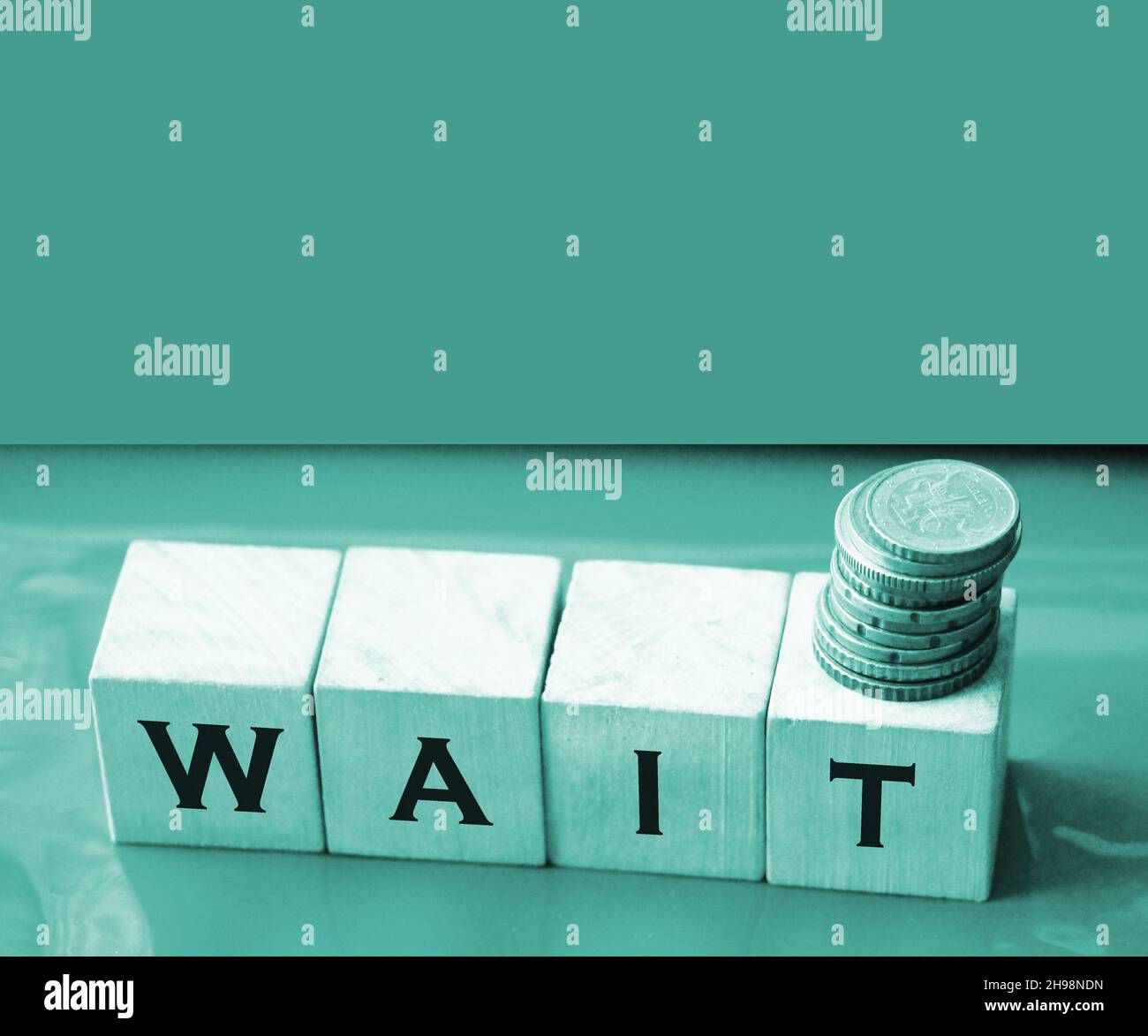 Wait text on a wooden cubes and coins. Business loan approval awaiting ...