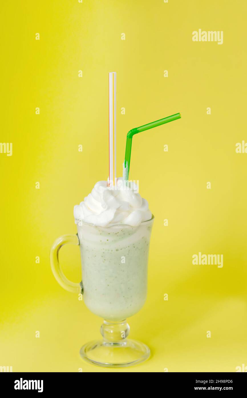 Cold green Peppermint milkshake on a yellow background Stock Photo - Alamy