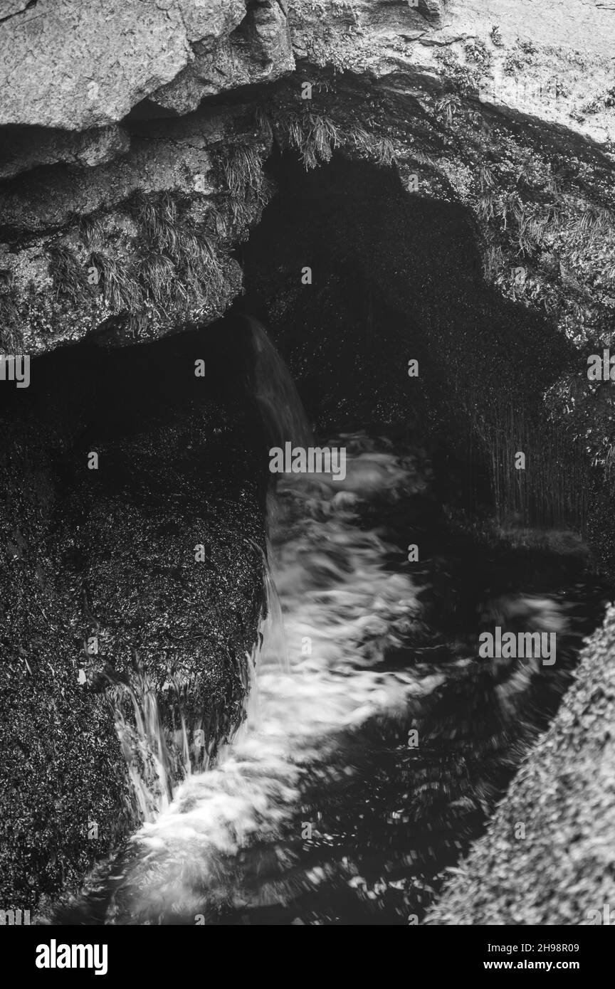 Rising tide waves crashing into a natural rock inlet called Thunder ...
