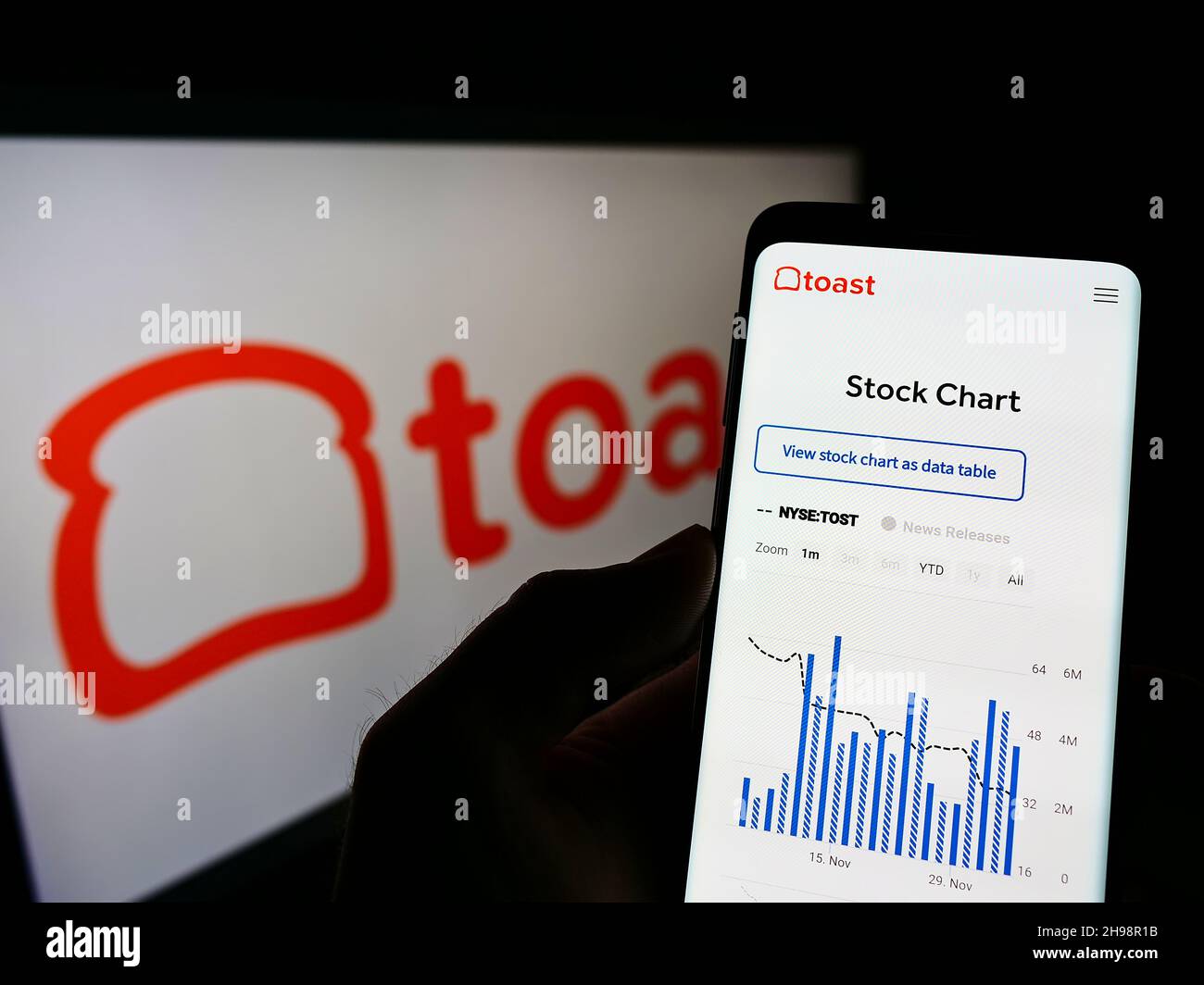 Person holding cellphone with webpage of US restaurant software company ...