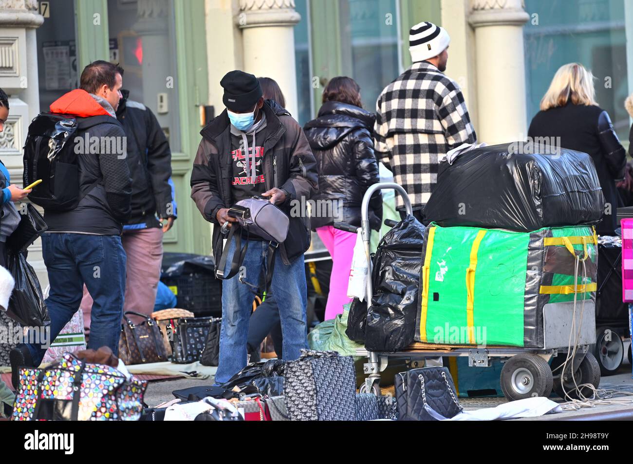 Street vendors are taking care of their wares on a busy street in ...