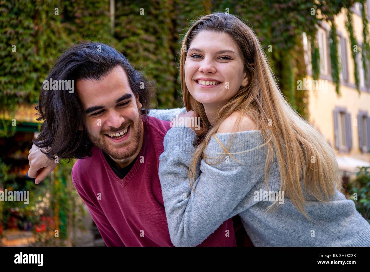 Young couple traveling to Rome. The beautiful blonde woman hugs her ...