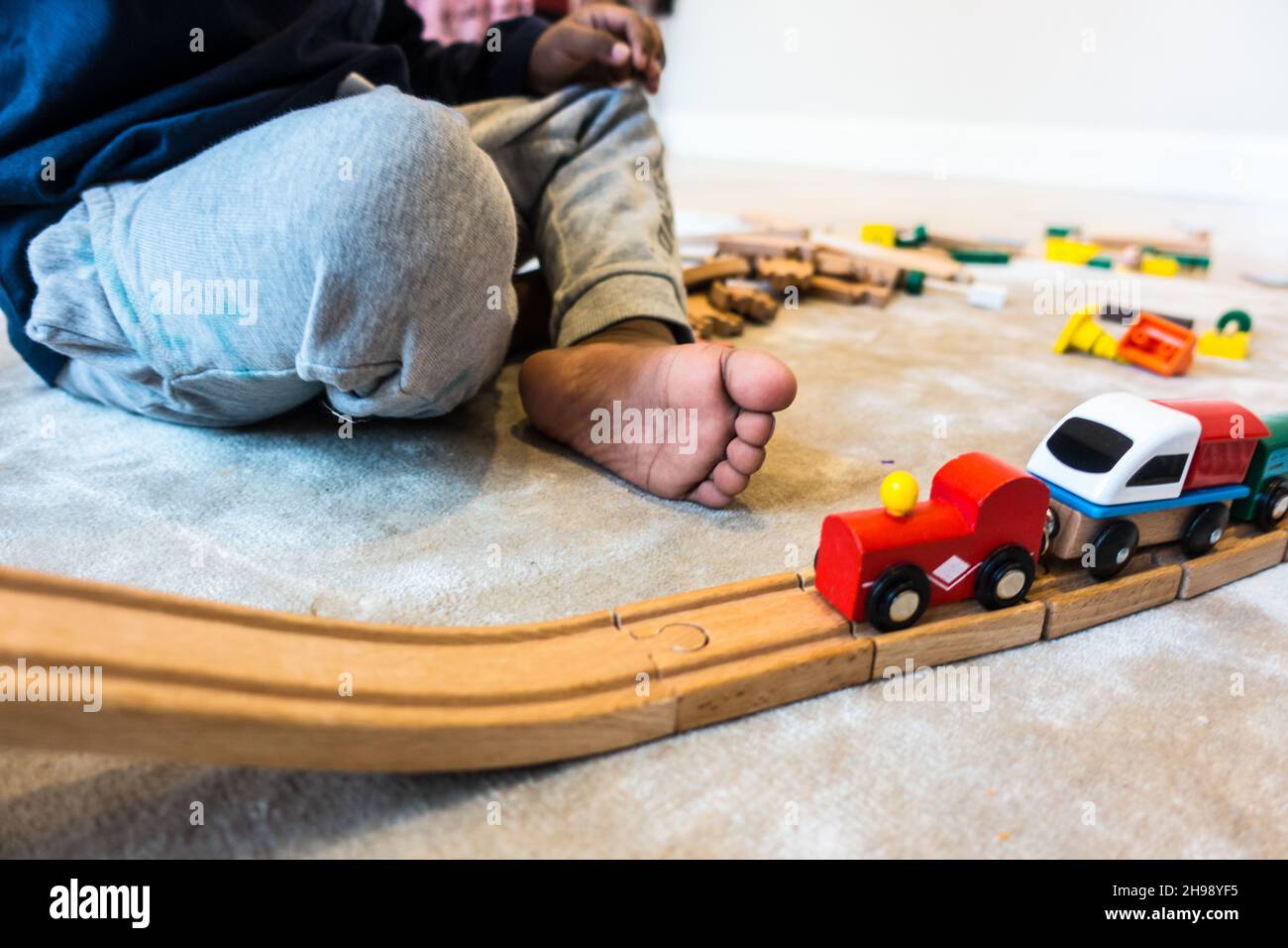 Boy playing with train toy. Indian boy aged 3 playing with a wooden ...