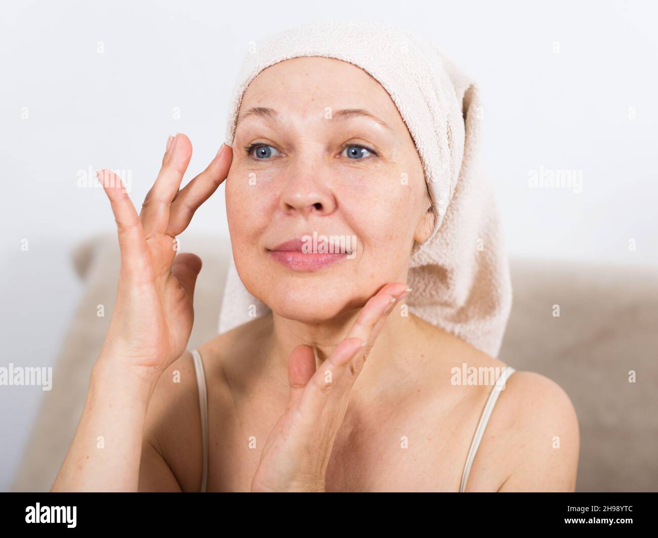 Woman using face cream Stock Photo - Alamy