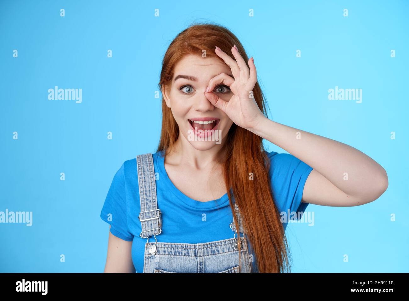 Dreamy curious attractive cheerful redhead woman surprised, look ...