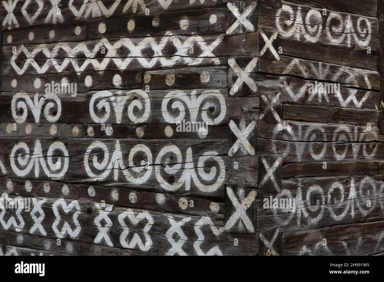 Detail of the traditional log house decorated with white linear ...