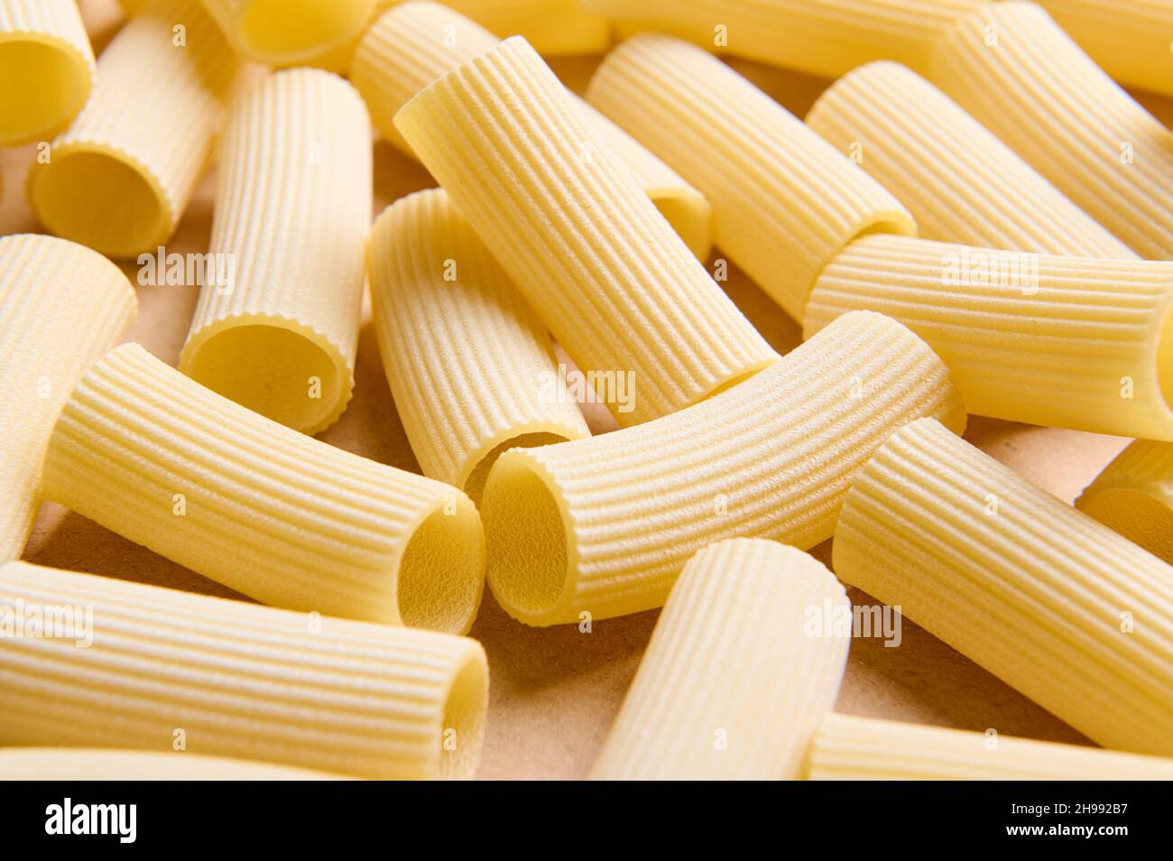 Pasta pattern. Close-up of a heap of uncooked whole wheat tortiglioni ...