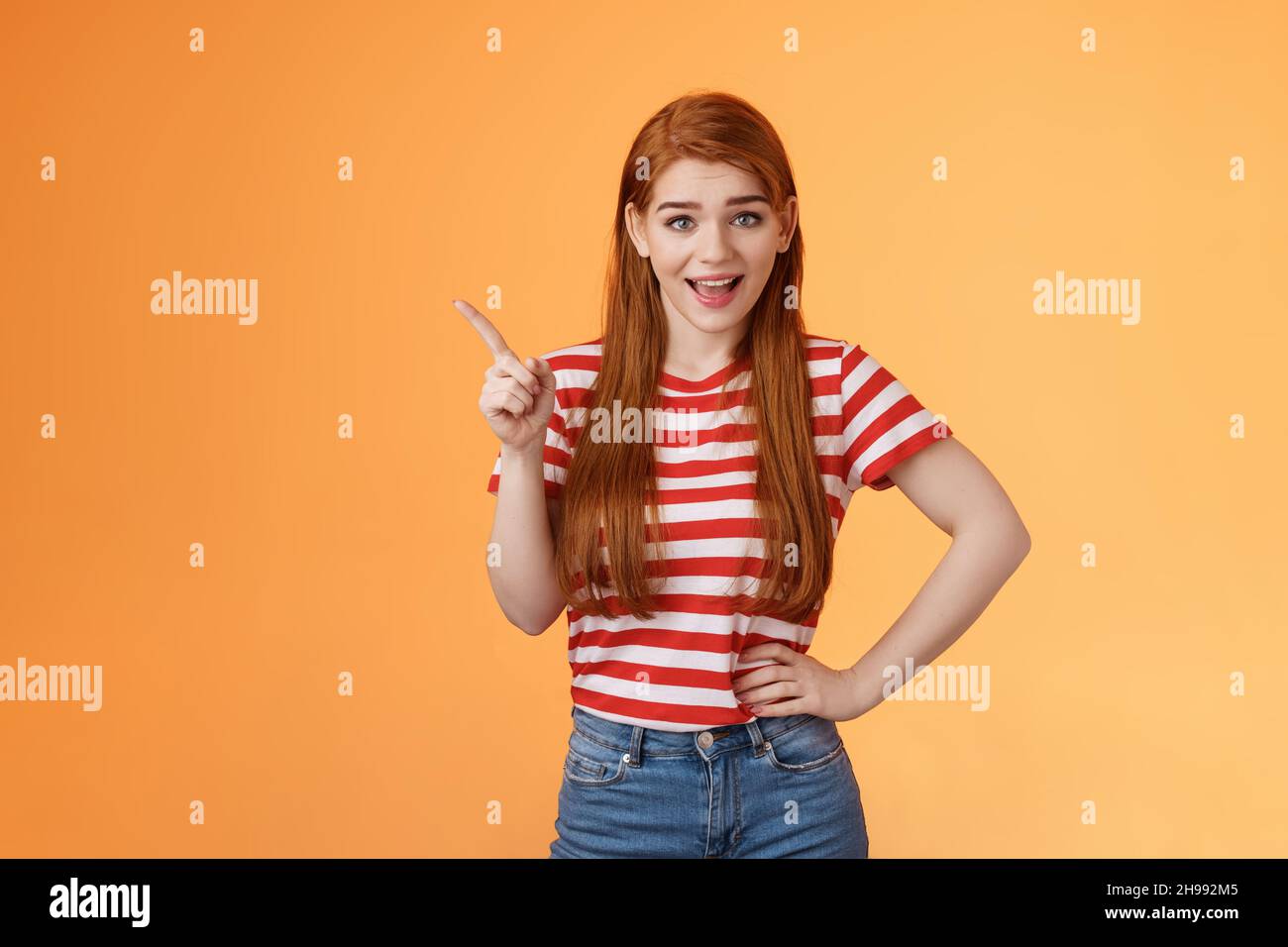 Lively friendly redhead woman discuss new trend pointing upper left ...