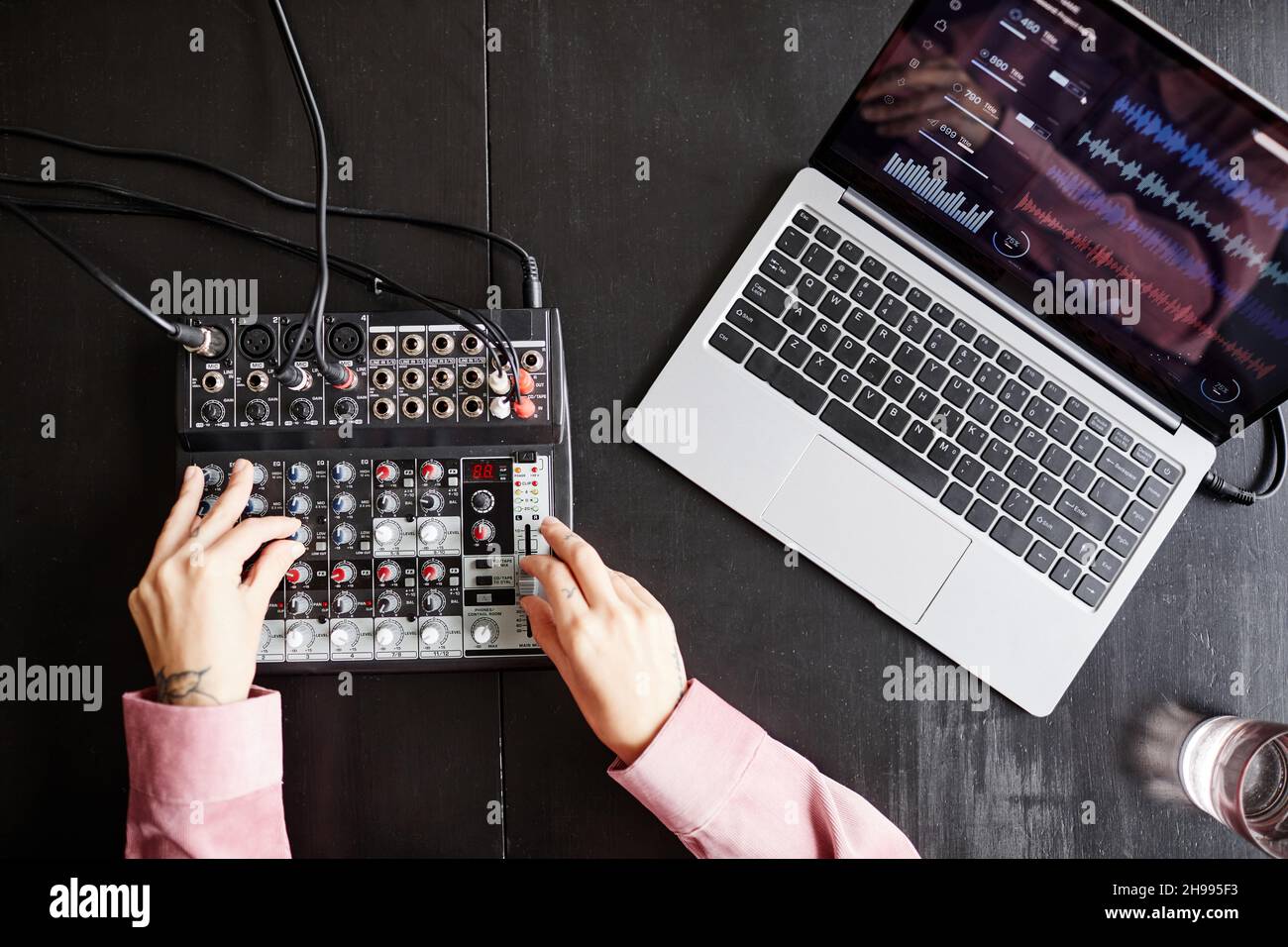 Top view close up of young female creator using audio mixer panel while ...