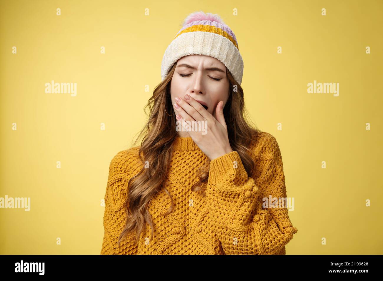Close-up shot tired yawning cute exhausted european woman wearing hat ...